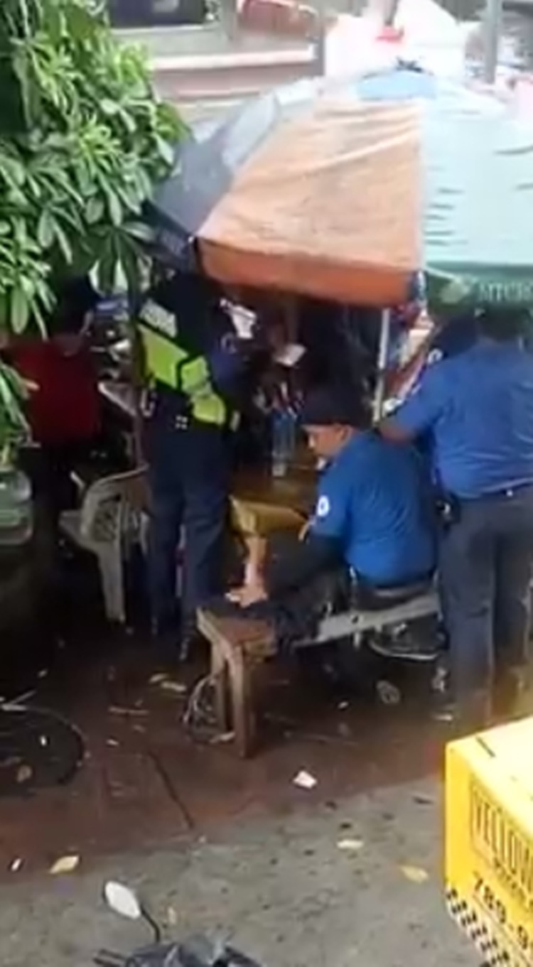 Traffic Enforcer Performs Duty Amidst Rain While Colleagues Hide Under ...