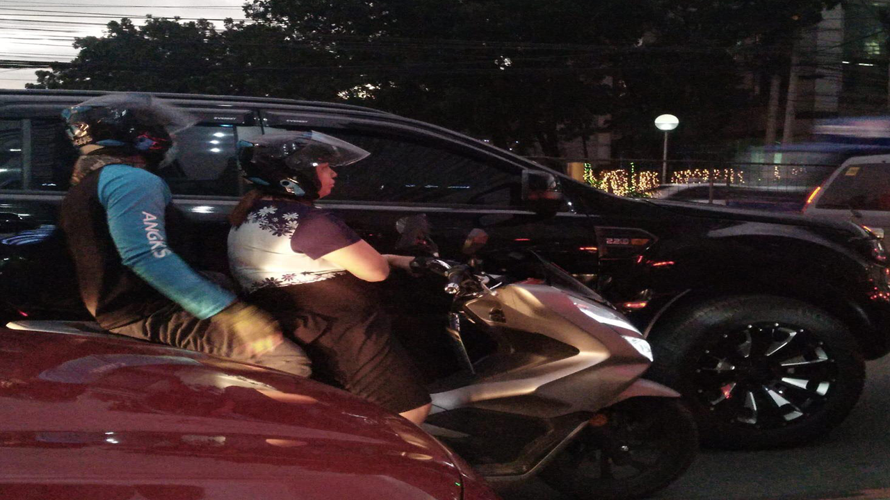 Photo of Angkas Rider Riding at the Back of Passenger Instead of Driving