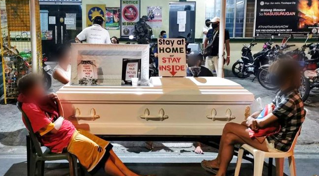 Curfew Violators In Parañaque City Seated Near Empty Coffins